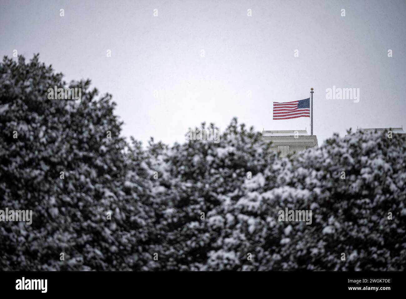 A U.S. Flag atop the Eisenhower Executive Office Building blow in the ...