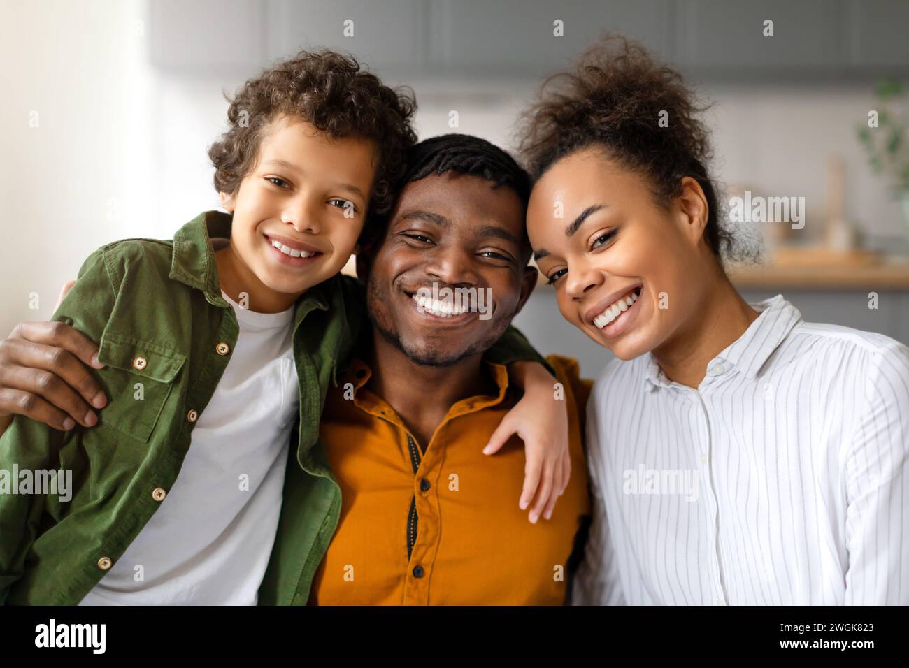 Black family with smiling parents and child boy in close hug Stock ...