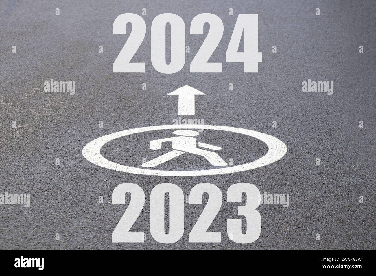 Forward arrow sign for a pedestrian on the asphalt, 2024 ahead and 2023 ...