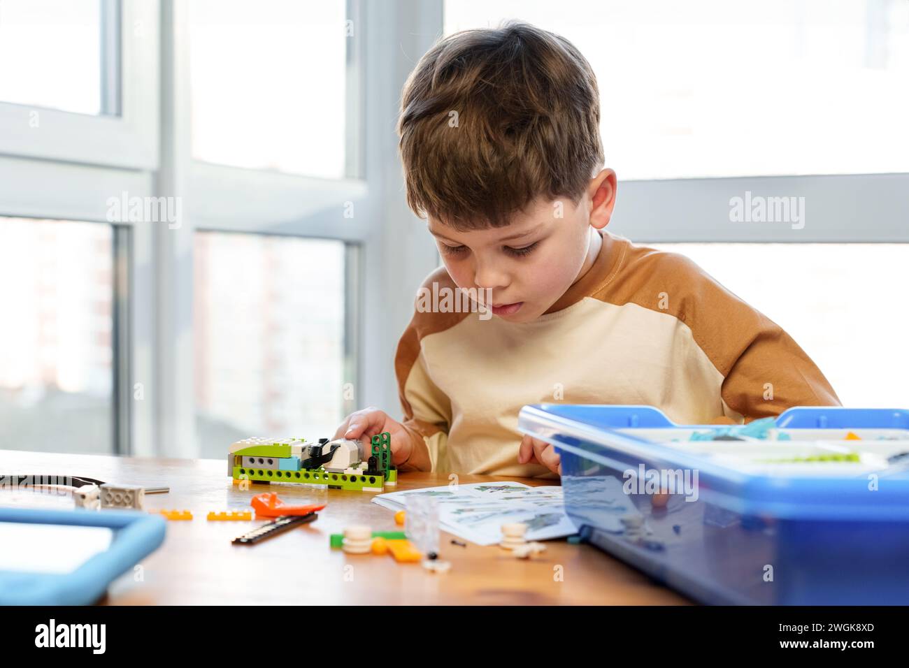 Smart boy assemble constructor. Smart child reading instruction ...