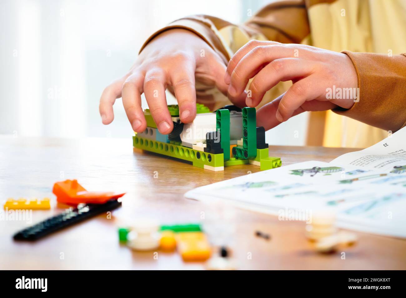 Close up hands child playing constructor pieces building instruction ...