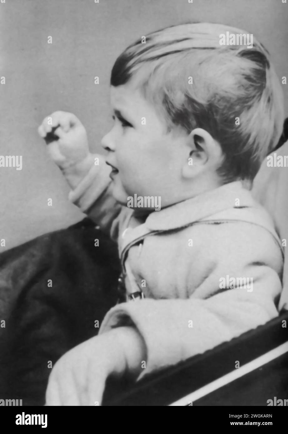 A young Charles III is shown in his baby stroller, in a photograph ...