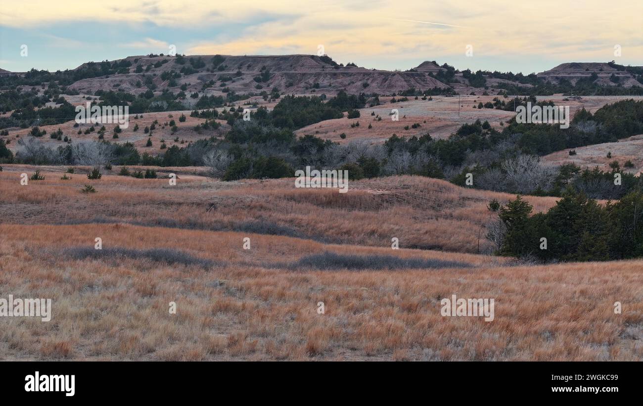 A sunset over hills and trees in the distance Stock Photo - Alamy