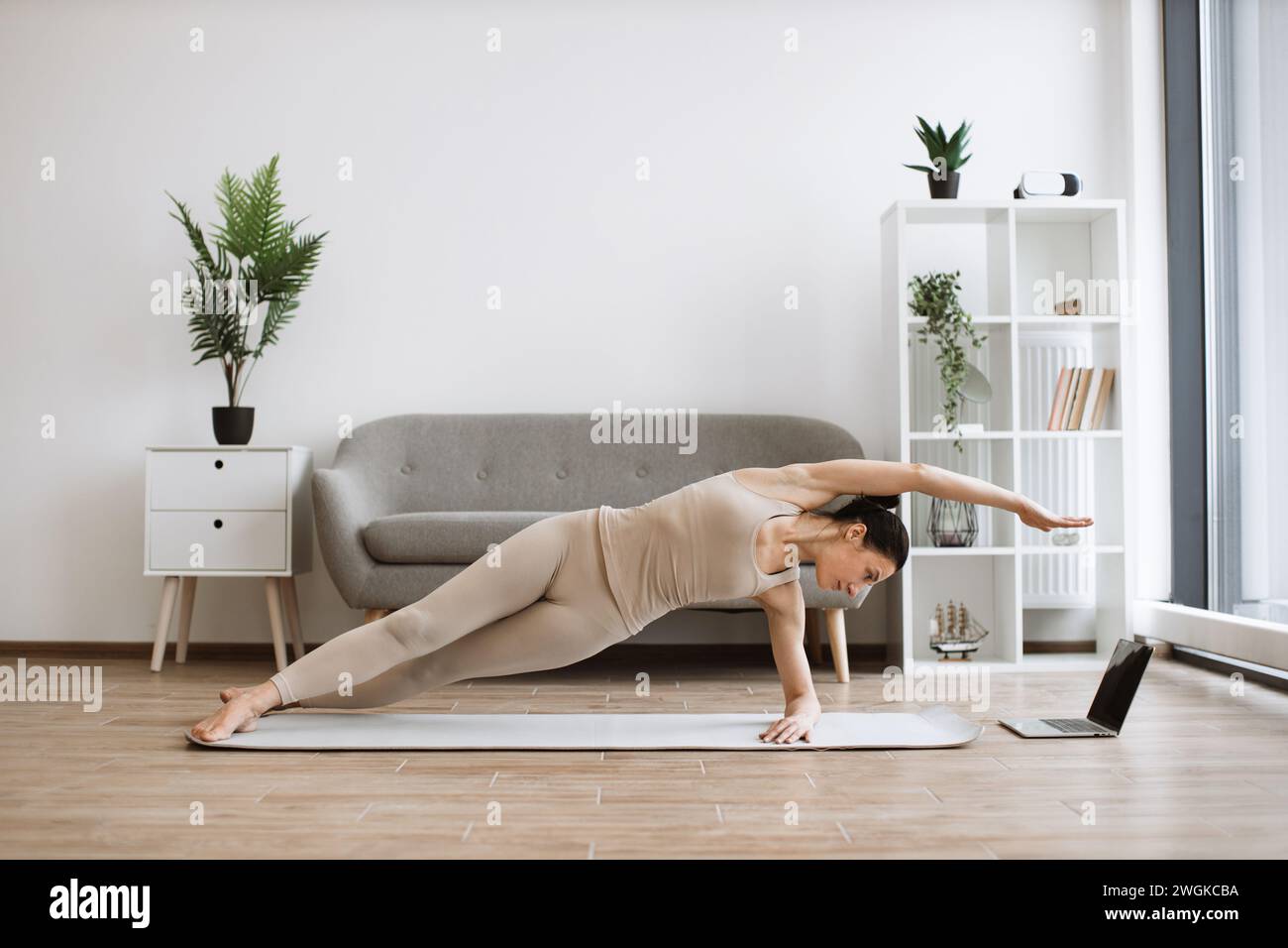 Healthy senior female practising modern yoga with Vasisthasana exercise ...