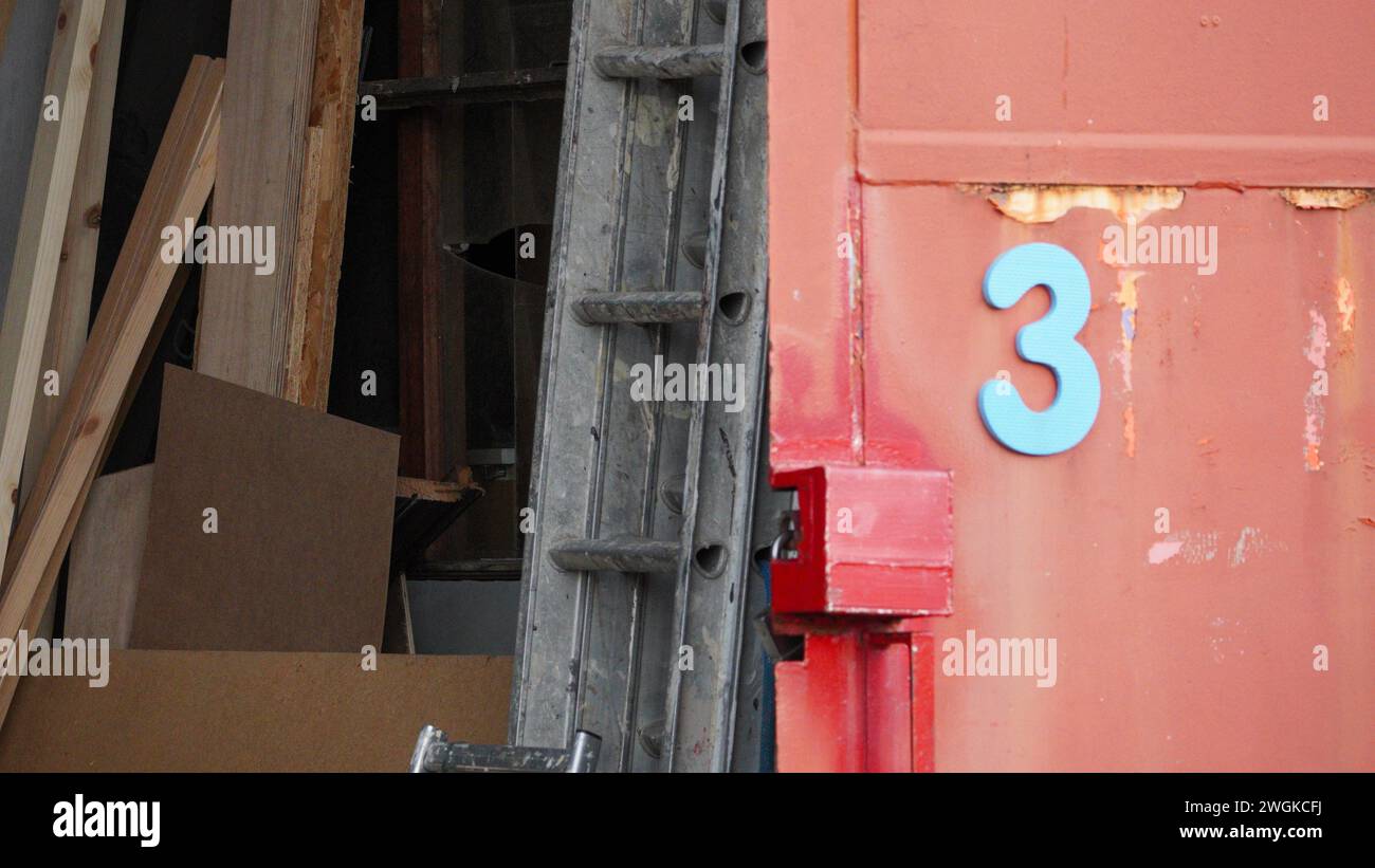 Orange red door with large blue number 3 on an industrial unit Stock ...