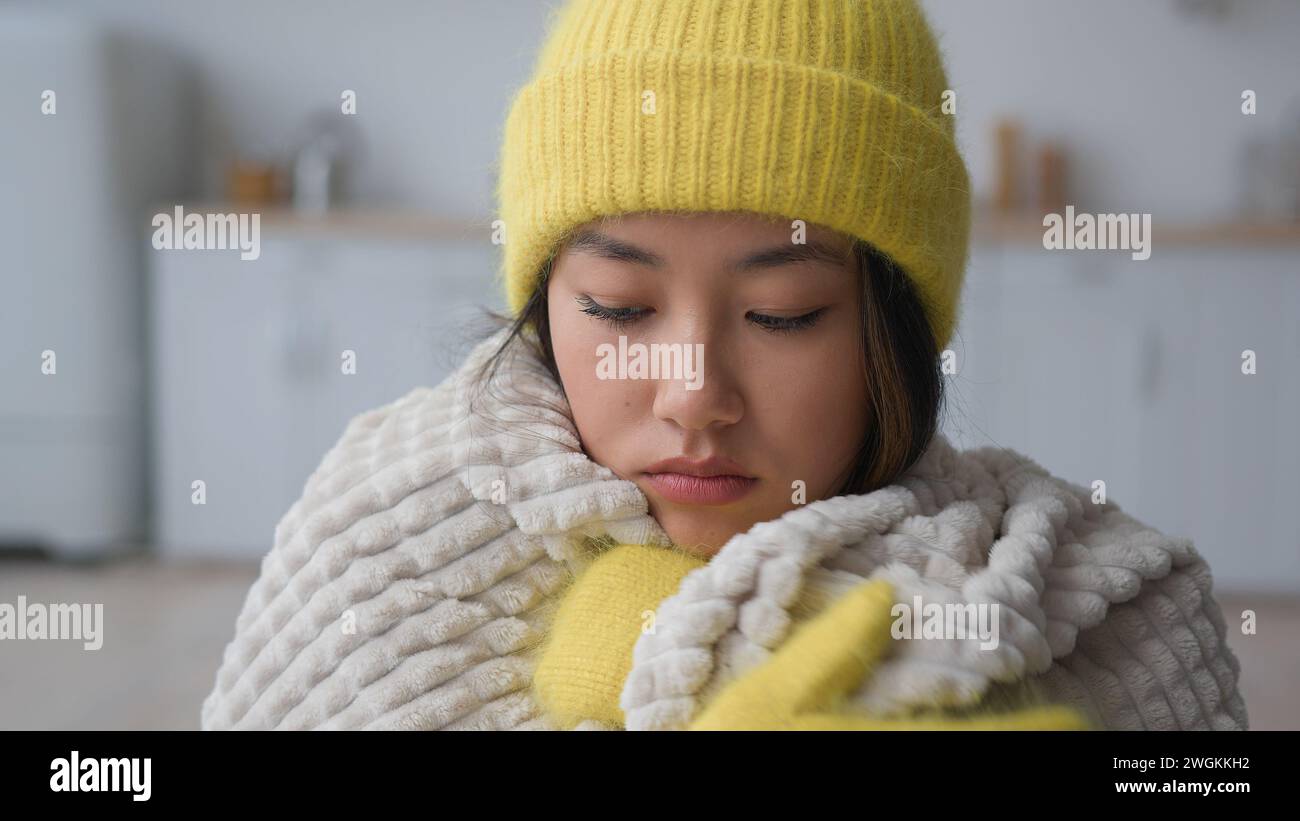 Sad upset Asian frozen chinese japanese korean woman at cold apartment ...