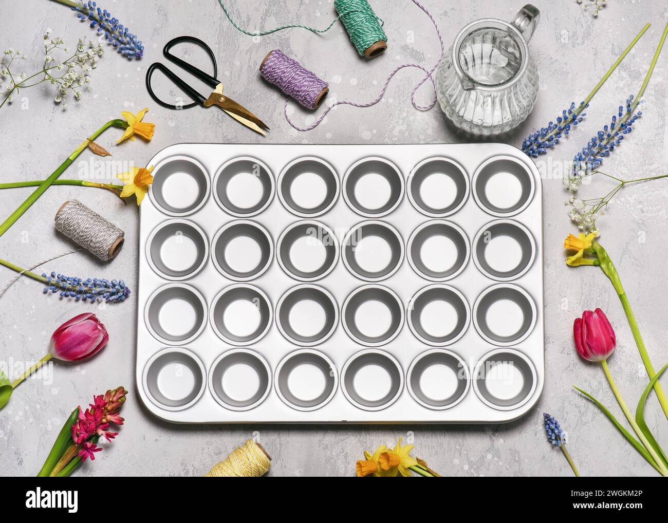 Top view of craft workplace with muffin tin, flowers and tools to ...