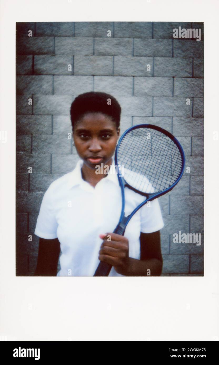 Portrait of a young african american woman with tennis racket on her ...