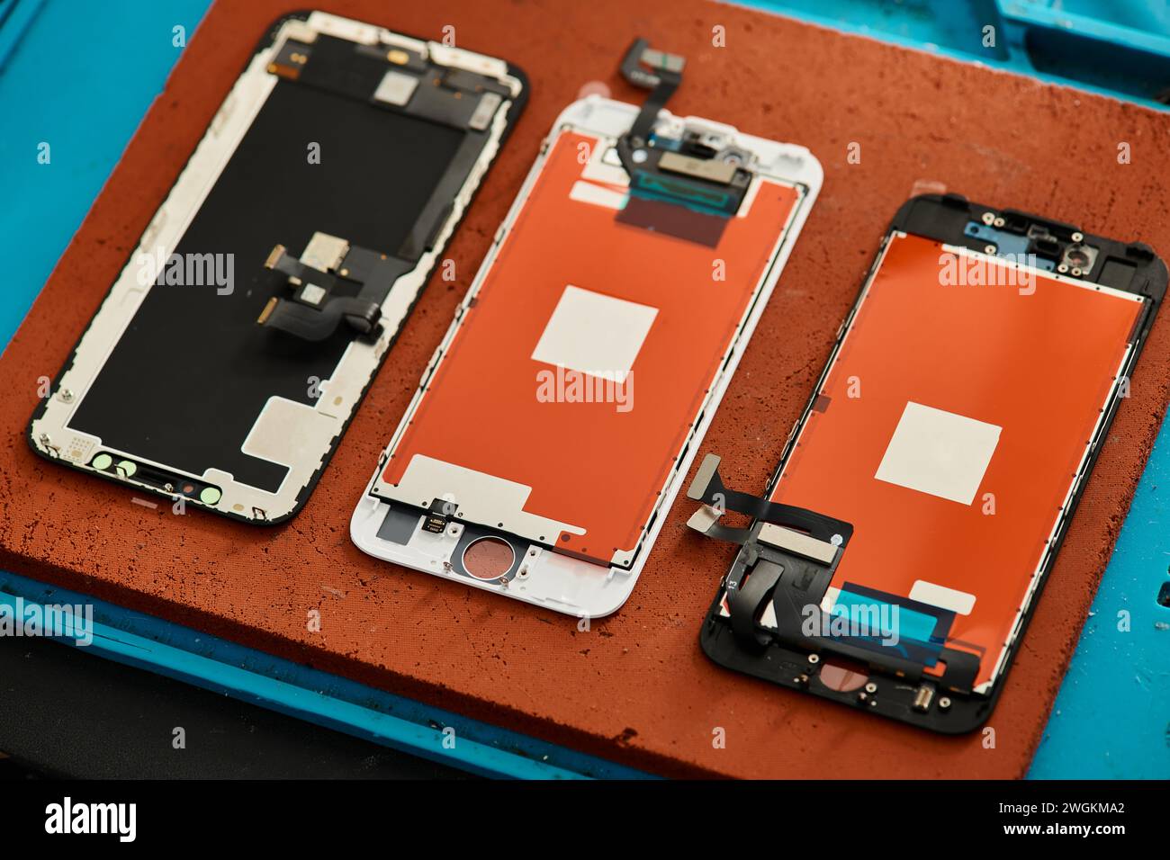 top view of disassembled mobile phones on table in repair shop, devices ...