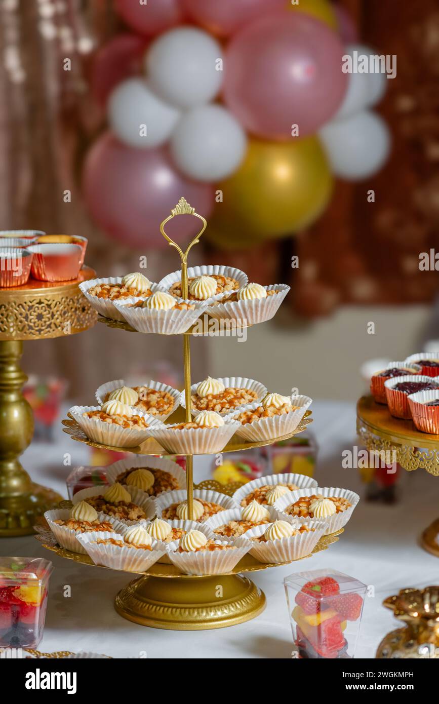 Birthday cupcakes on three tiered display stand festive balloons in the ...