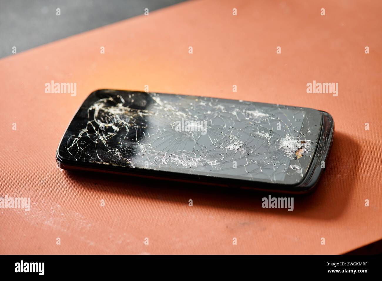 modern mobile phone with broken touchscreen on table in repair workshop ...