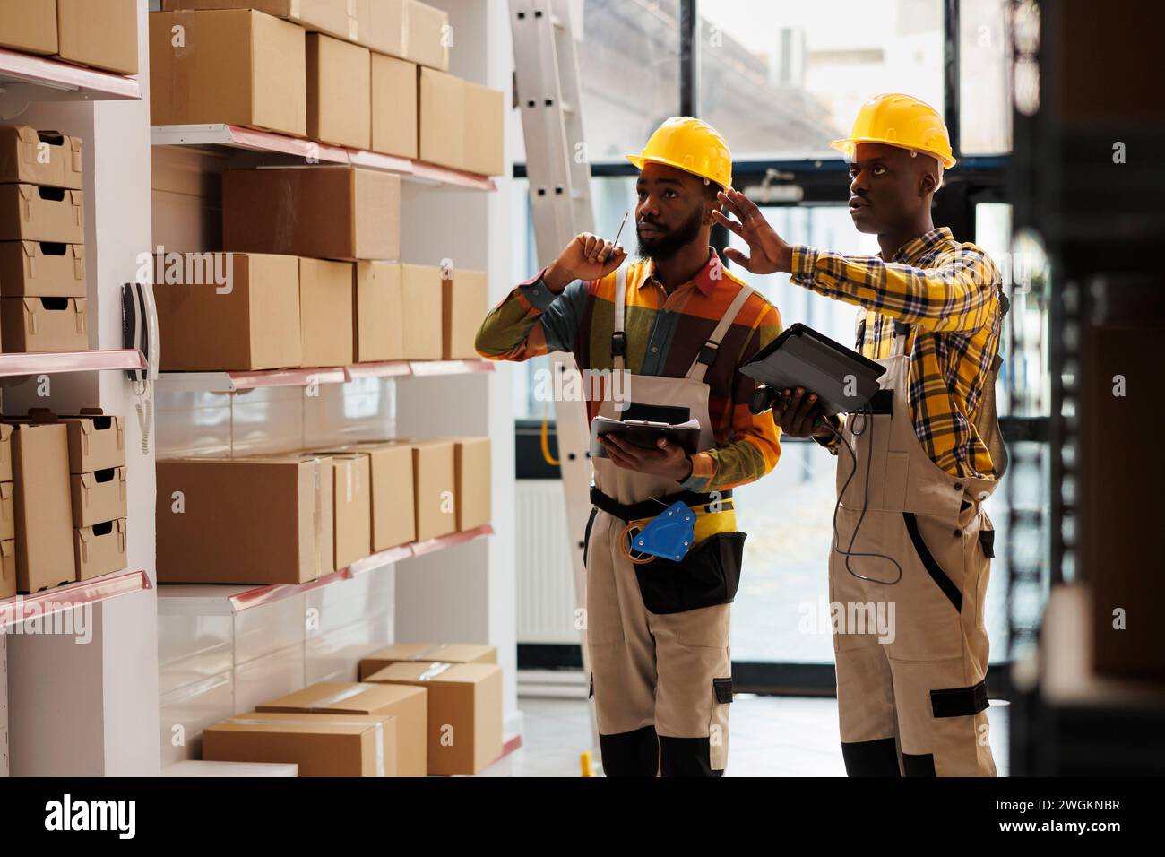 Warehouse manager training assistant doing inventory with barcode ...