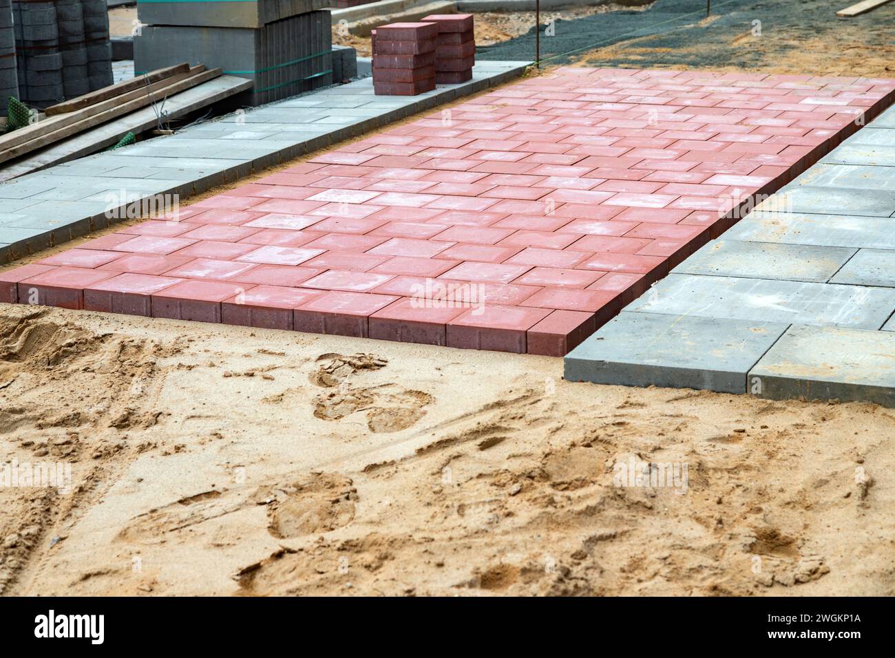 Red concrete blocks for cycle path in the sand bed Stock Photo - Alamy