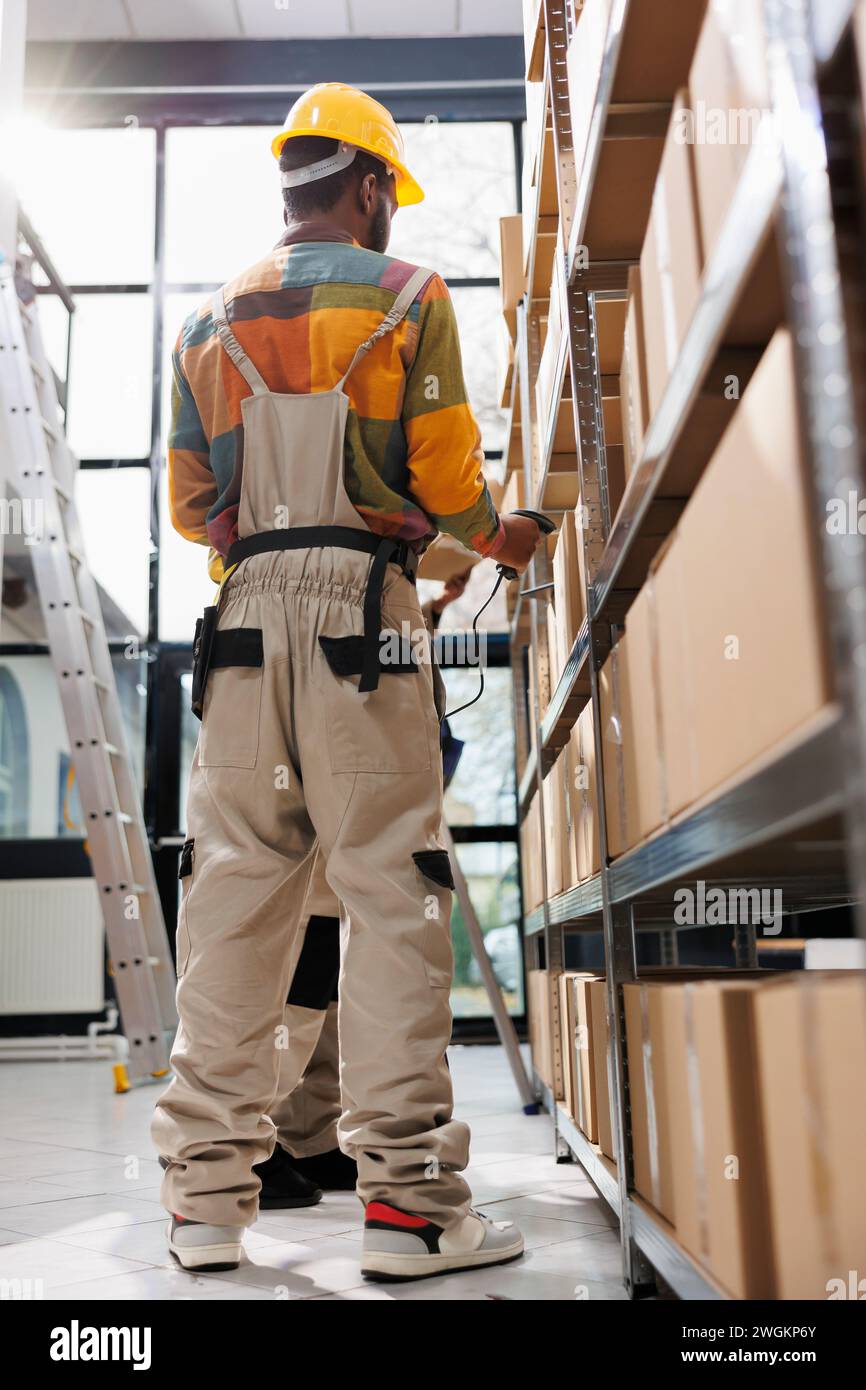 Warehouse employees managing products storing using barcode scanner ...