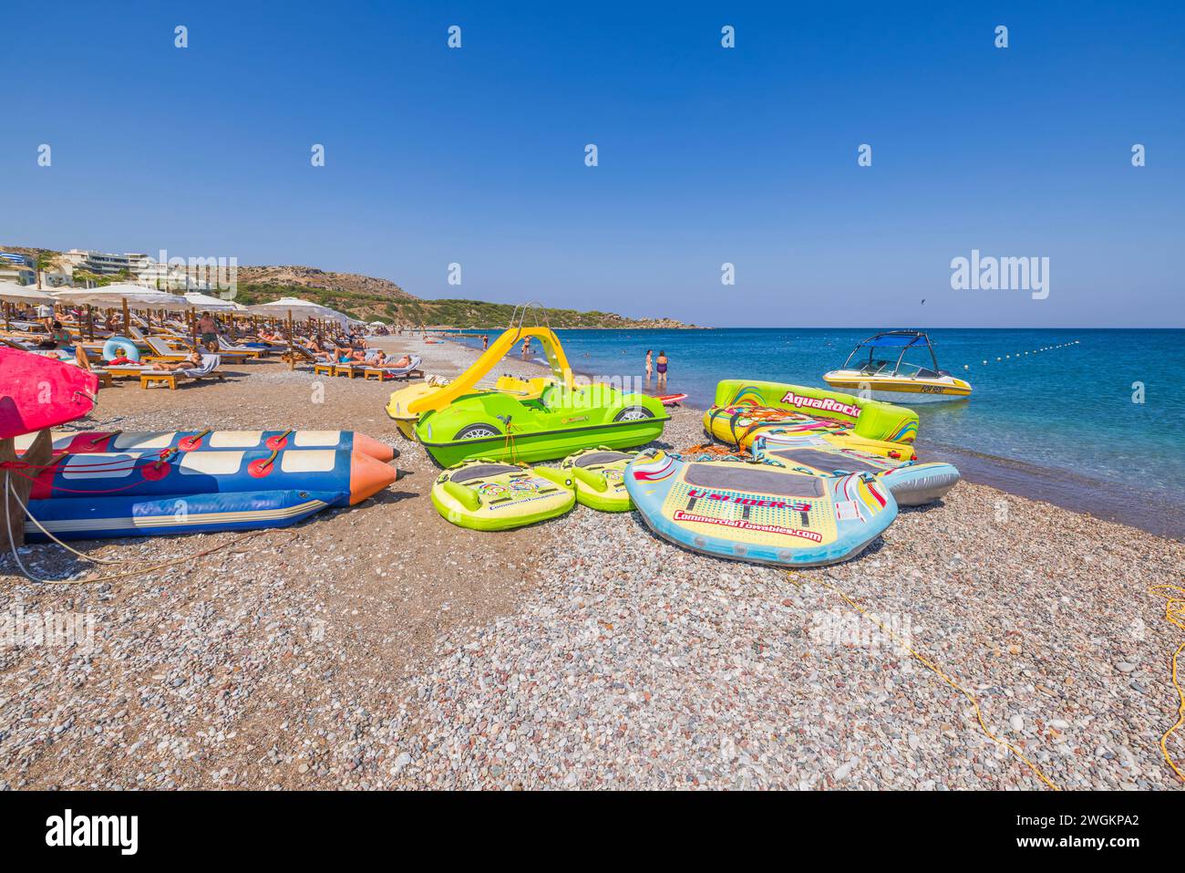 Colorful inflatable tubes on the beach, set to pull beach lovers into ...