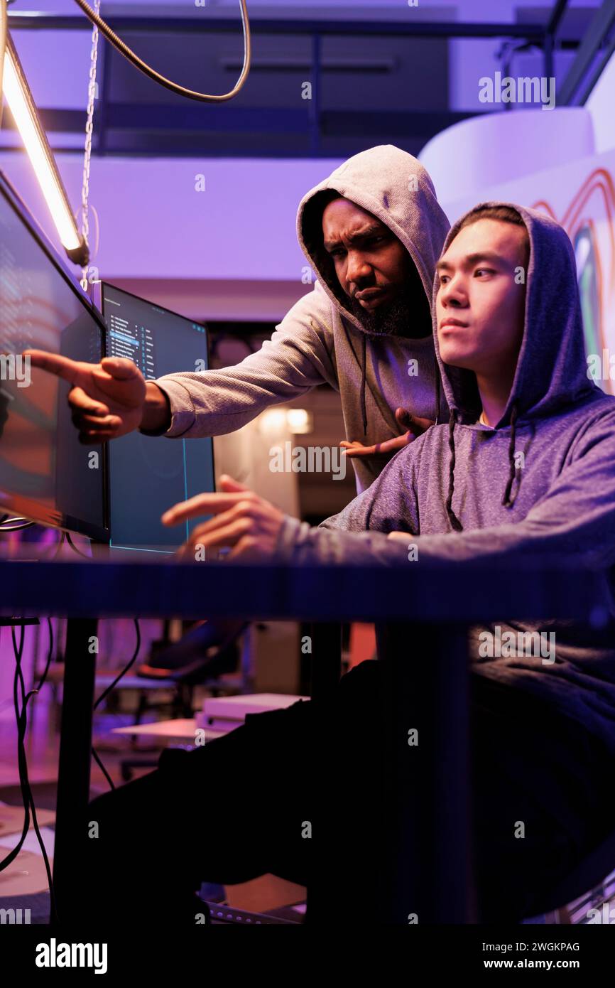 Confused hacker pointing at computer screen and asking criminal about ...