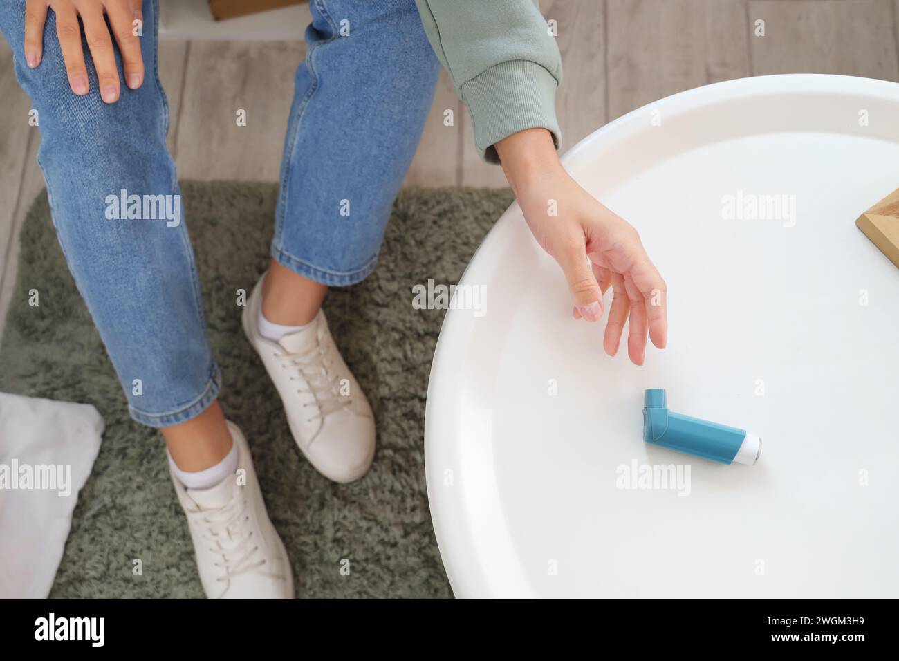 Young woman taking asthma inhaler from table at home, closeup Stock ...