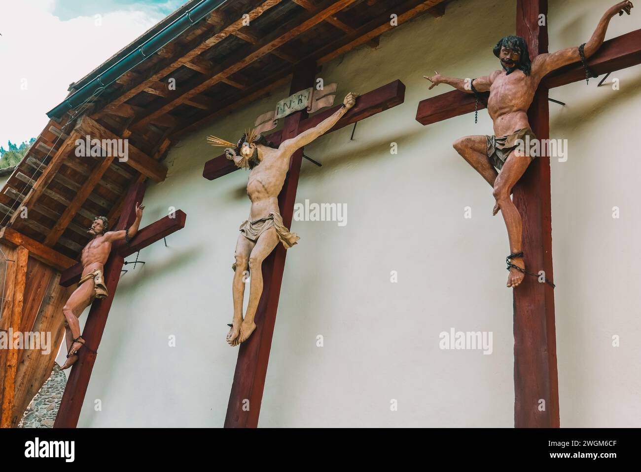Jesus Christ and two martyrs crucifixion on wooden crosses in the Church of St. Leonard.Church ...