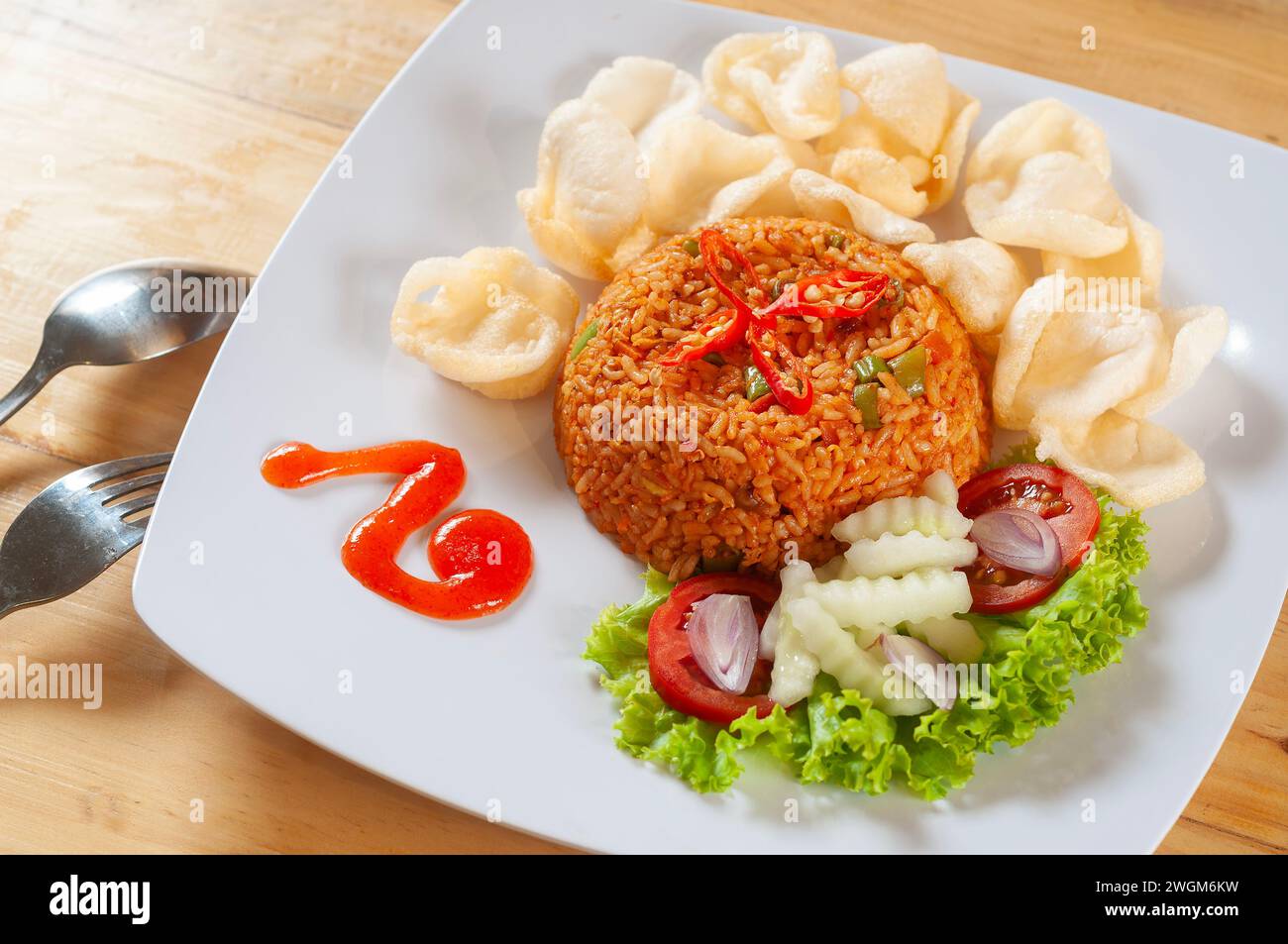 spicy fried rice placed on a plate decorated with crackers and ...
