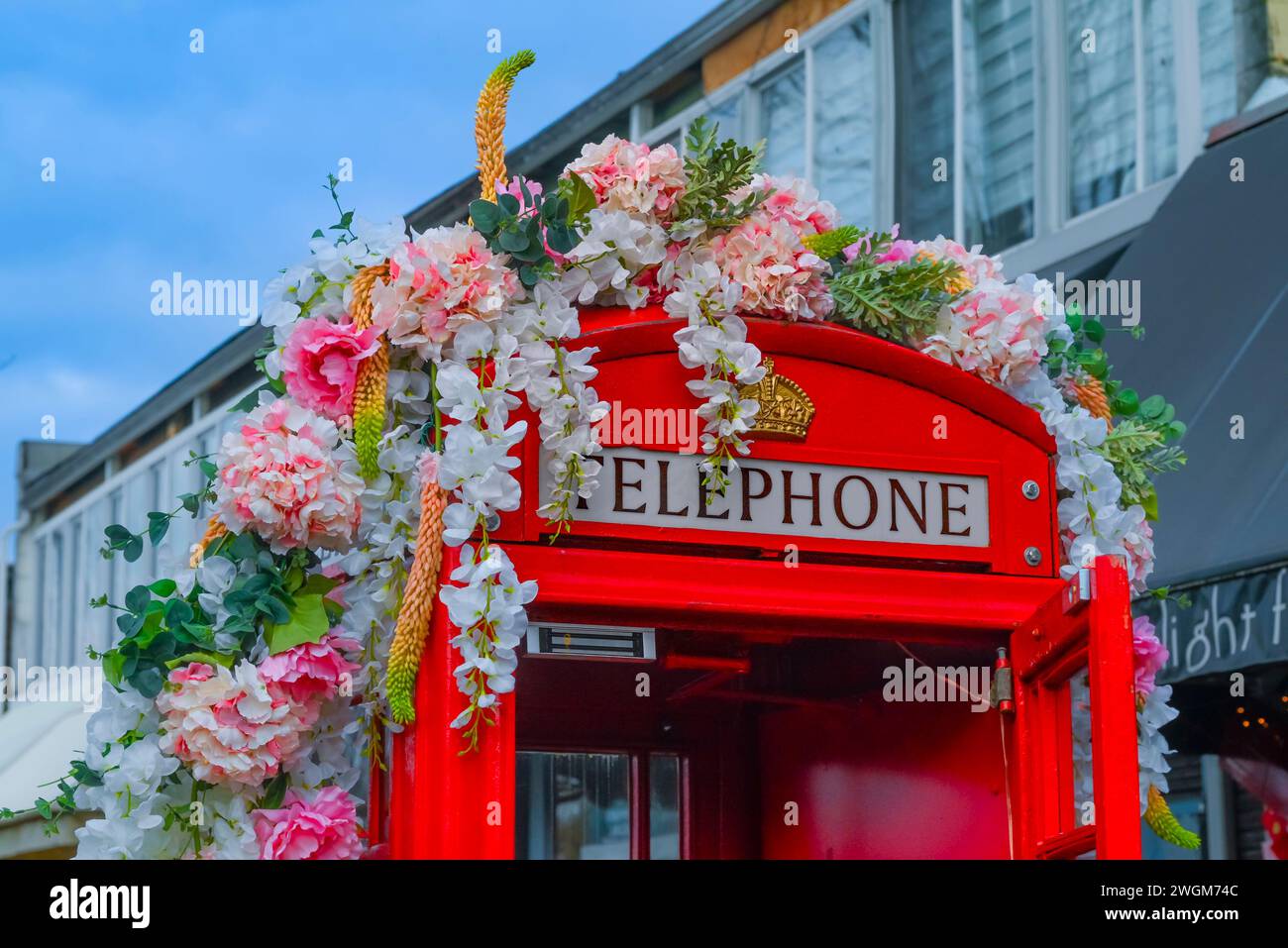 Red English Telephone booth with flower decorations Stock Photo - Alamy