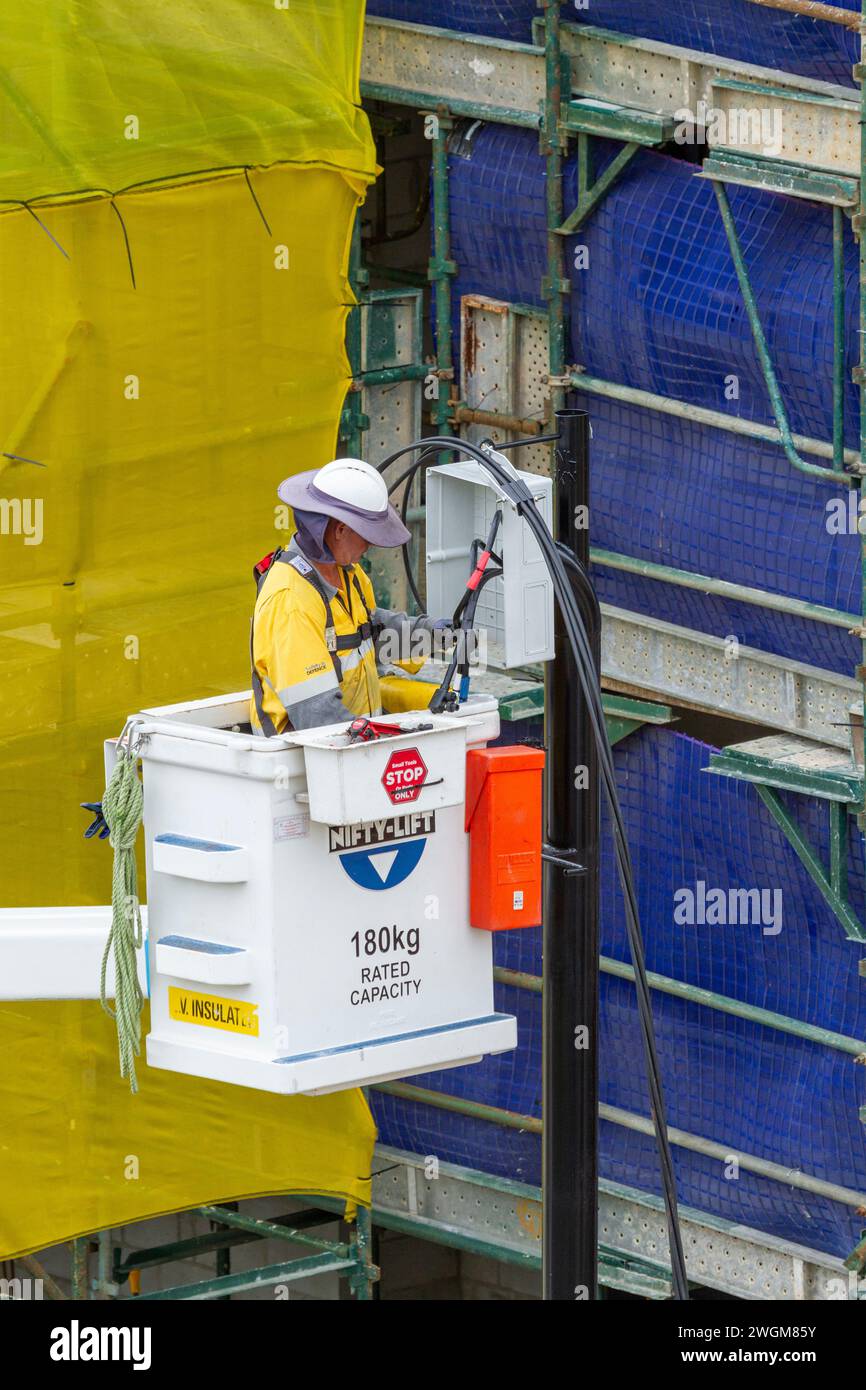 Electricity Lineman working on power line infrastructure from a lift ...