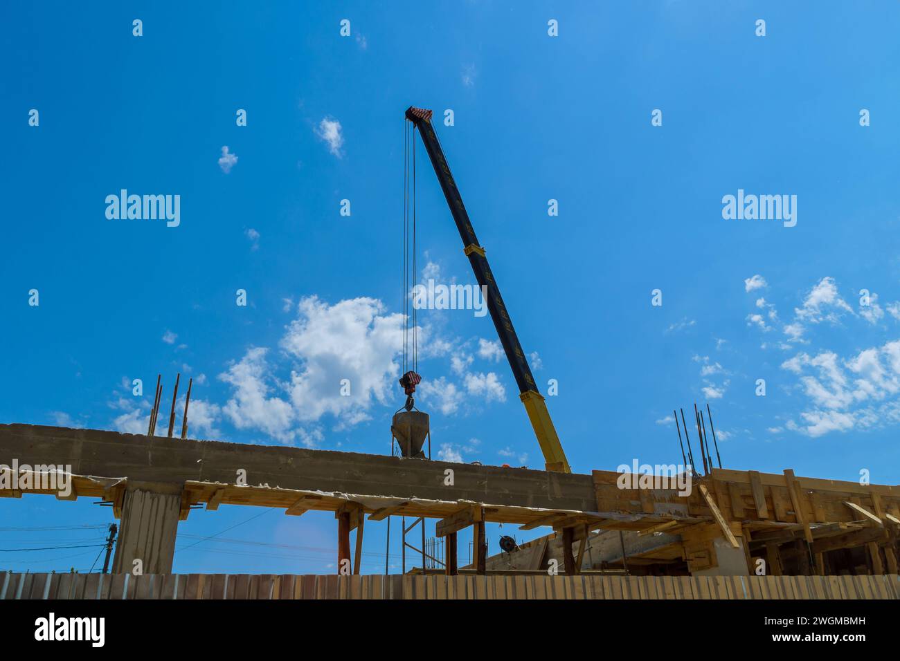 During construction process, tower crane is lifting concrete bucket in ...