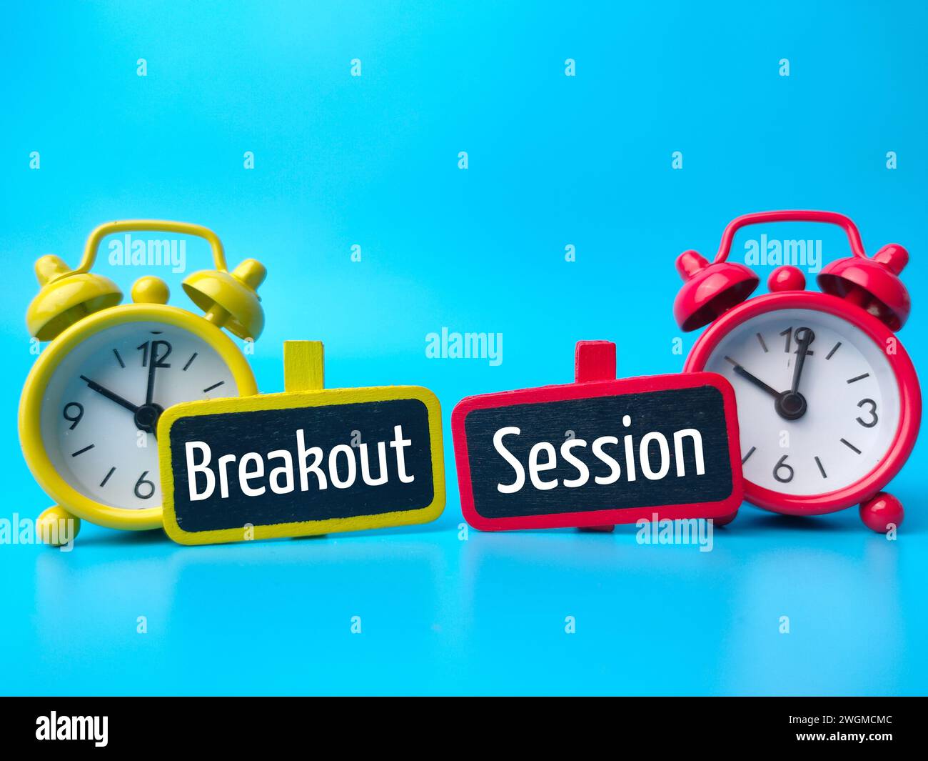 Alarm clock and wooden board with text Breakout Session on blue ...