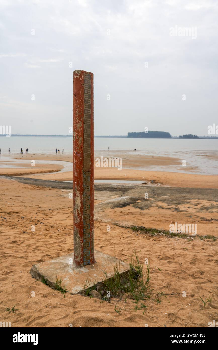 Close-up of a ruler measuring water depth on the beach at the seaside ...