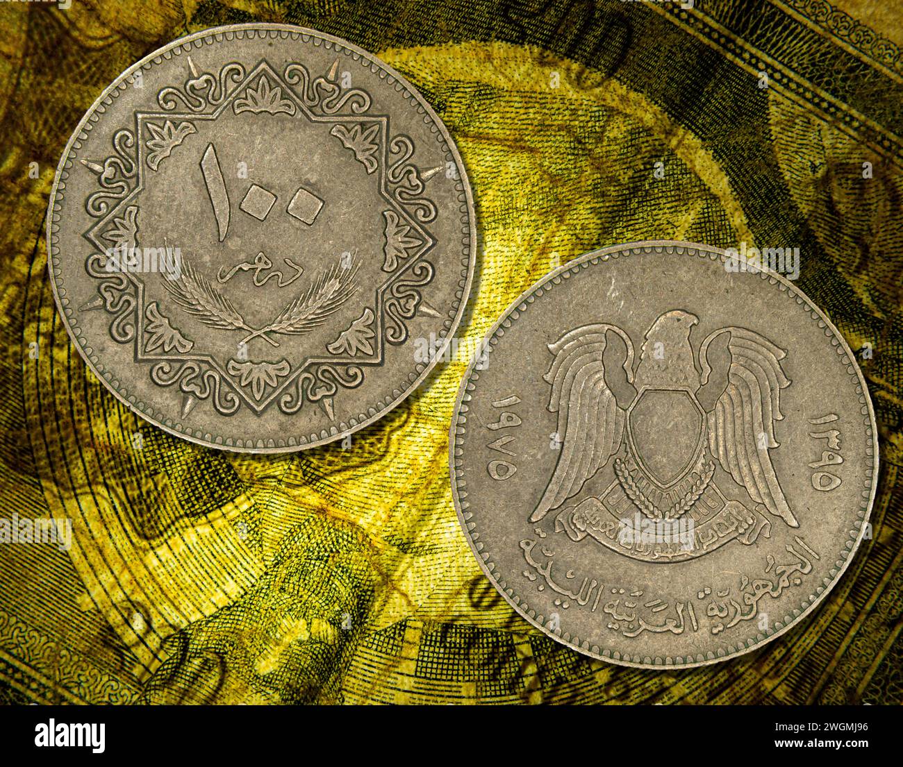 Two vintage Libyan Jamahiriya dinar coins placed on a vibrant yellow ...
