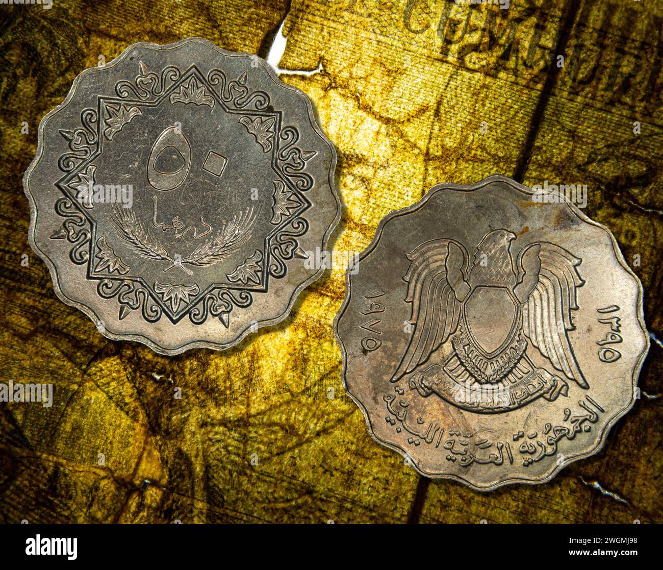 Two vintage Libyan Jamahiriya dinar coins placed on a vibrant black ...