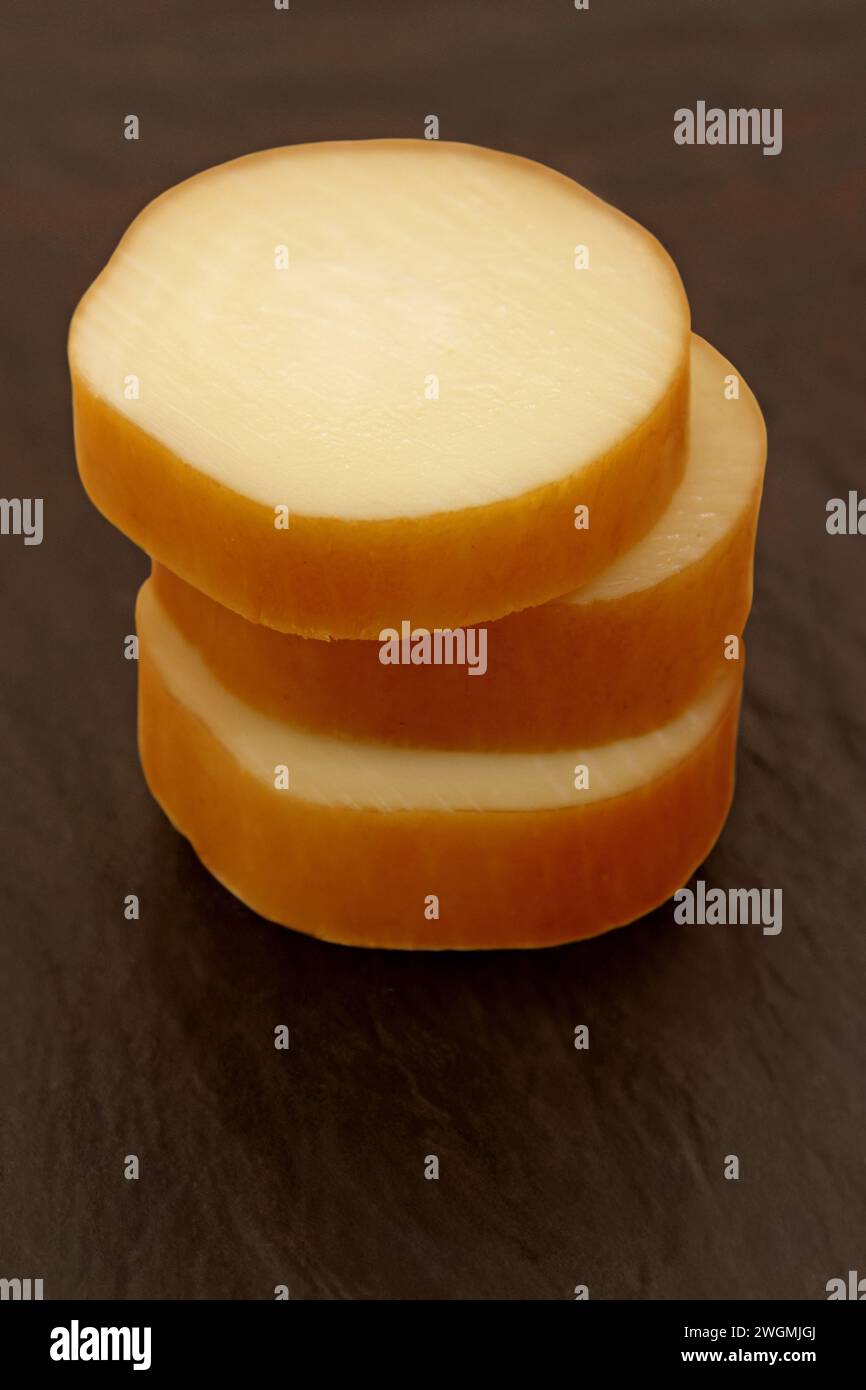 SMOKED PROVOLONE CHEESE IN PIECES ON THE DARK TABLE Stock Photo - Alamy