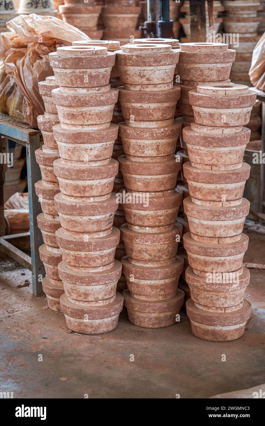 Neatly stacked clay embryos and molds in a traditional Chinese pottery ...