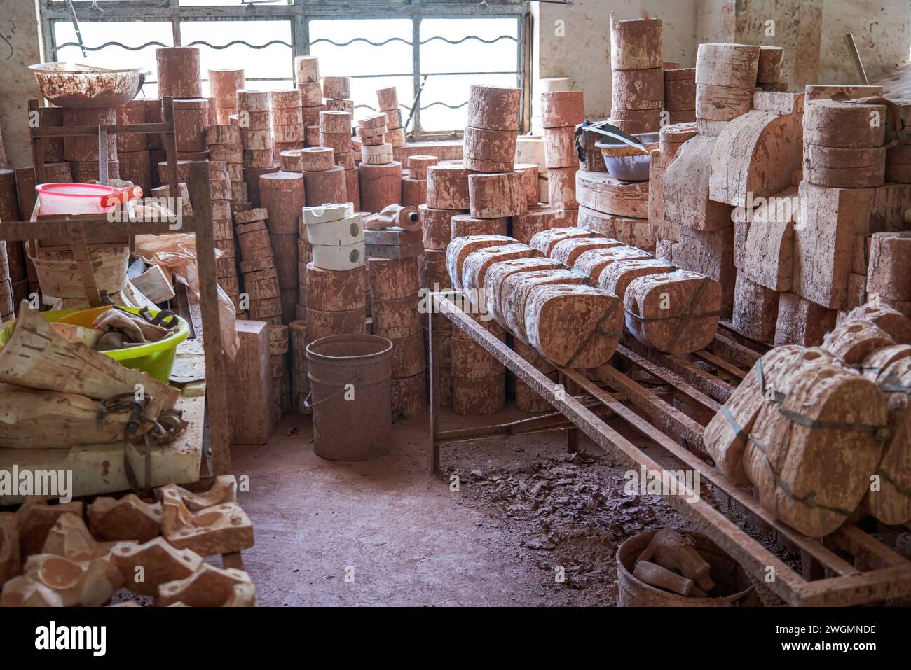 Neatly stacked clay embryos and molds in a traditional Chinese pottery ...