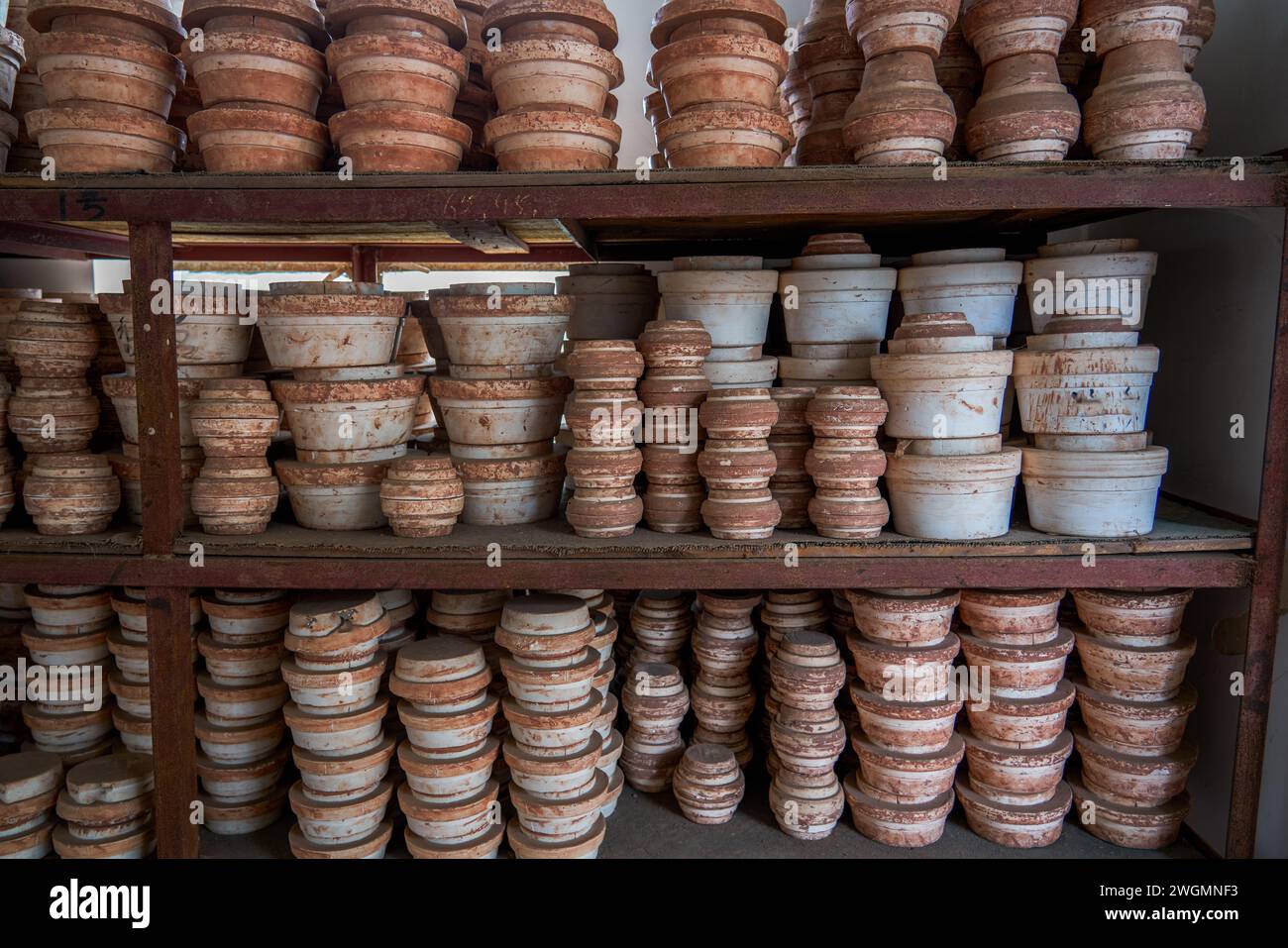 Neatly stacked clay embryos and molds in a traditional Chinese pottery ...