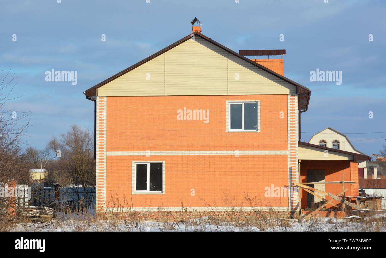 Unfinished brick house construction with incomplete rain gutter ...