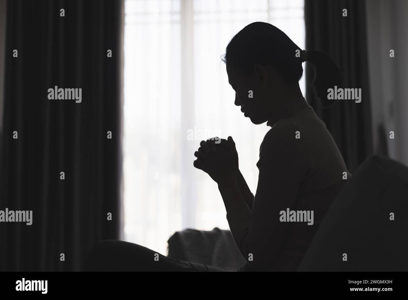 Silhouette of a person praying to god and holy things, religious ...