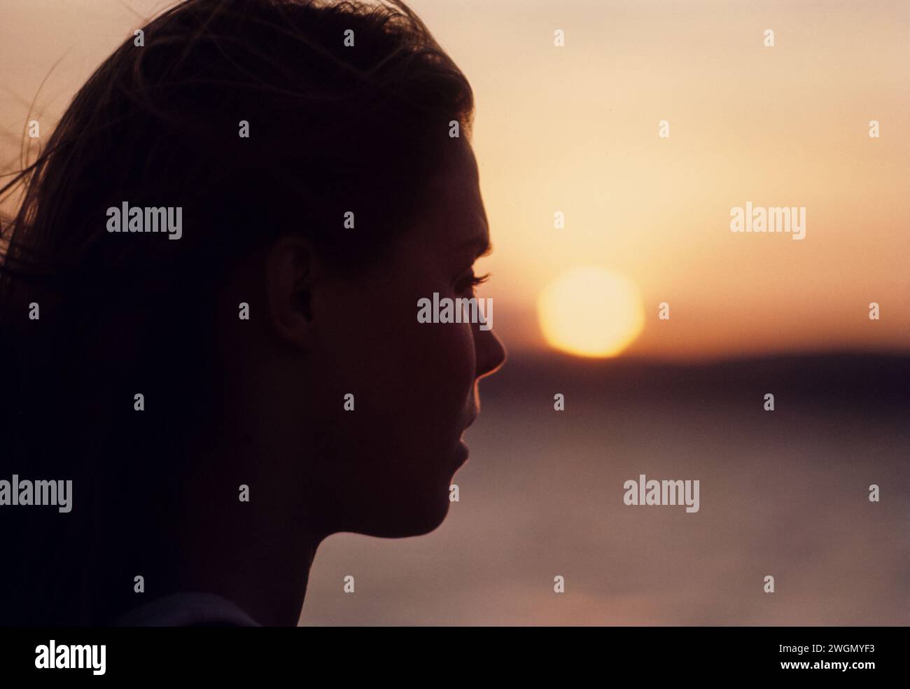 pretty blond hair young woman underlight portrait profil face sunset ...