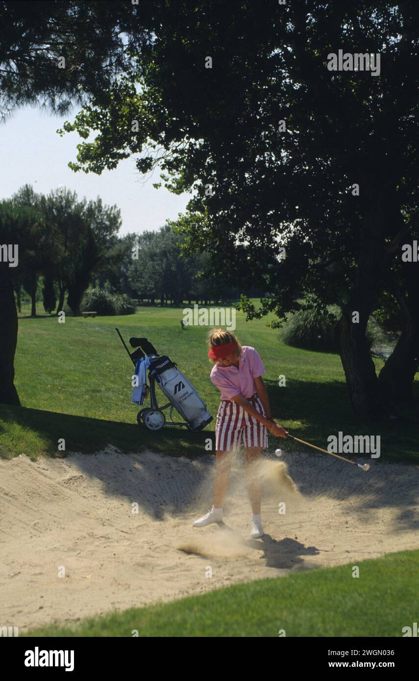 blond hair attractive woman playing golf on bunker green grass and tree ...
