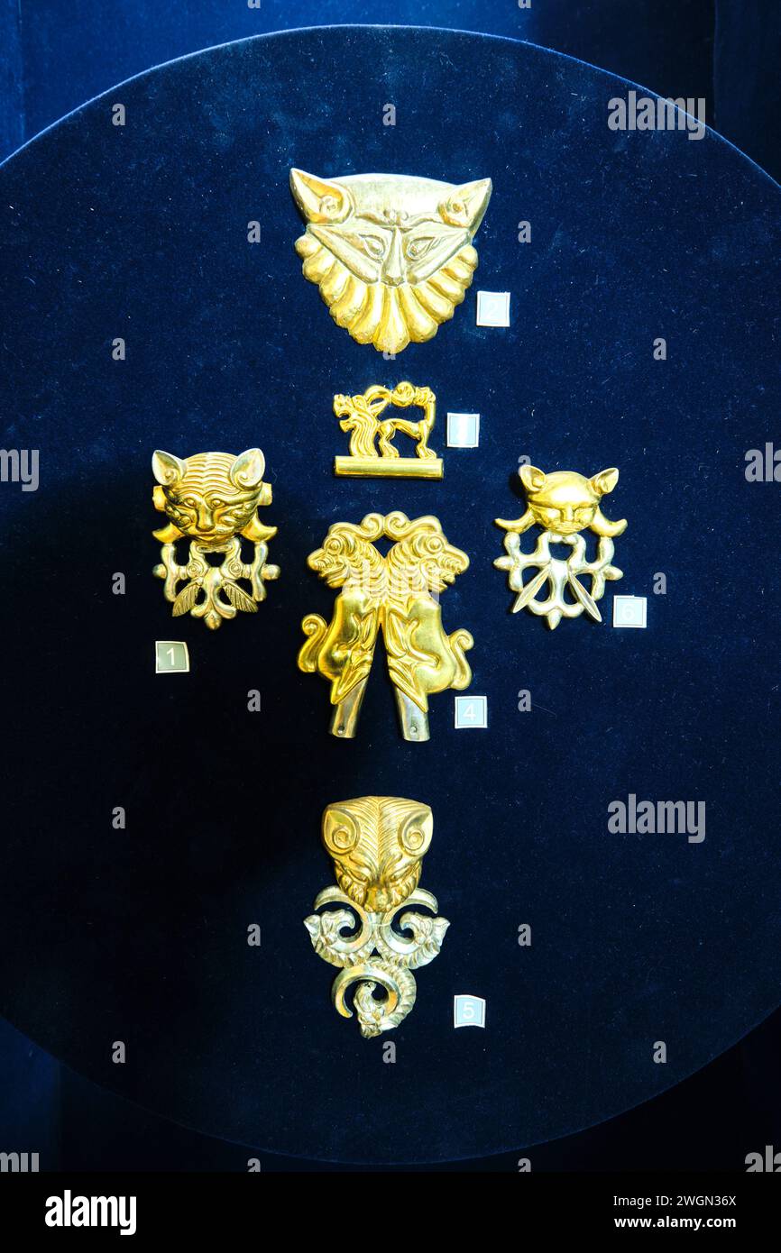 A collection of small, gold, flat figures, including the images, masks ...