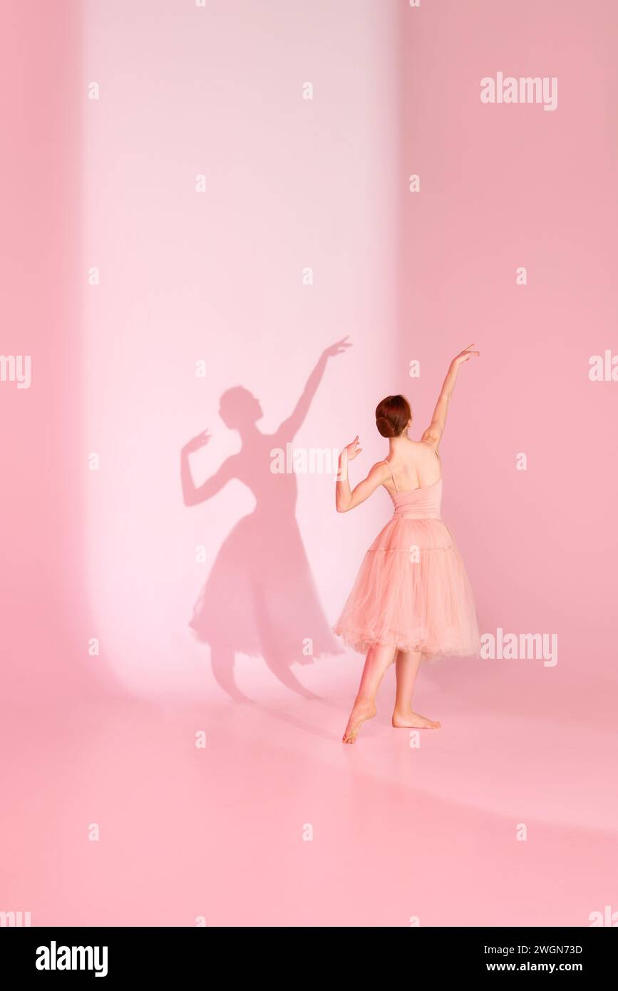 Balletic Grace. Classic ballerina dances barefoot in pink swimsuit and ...