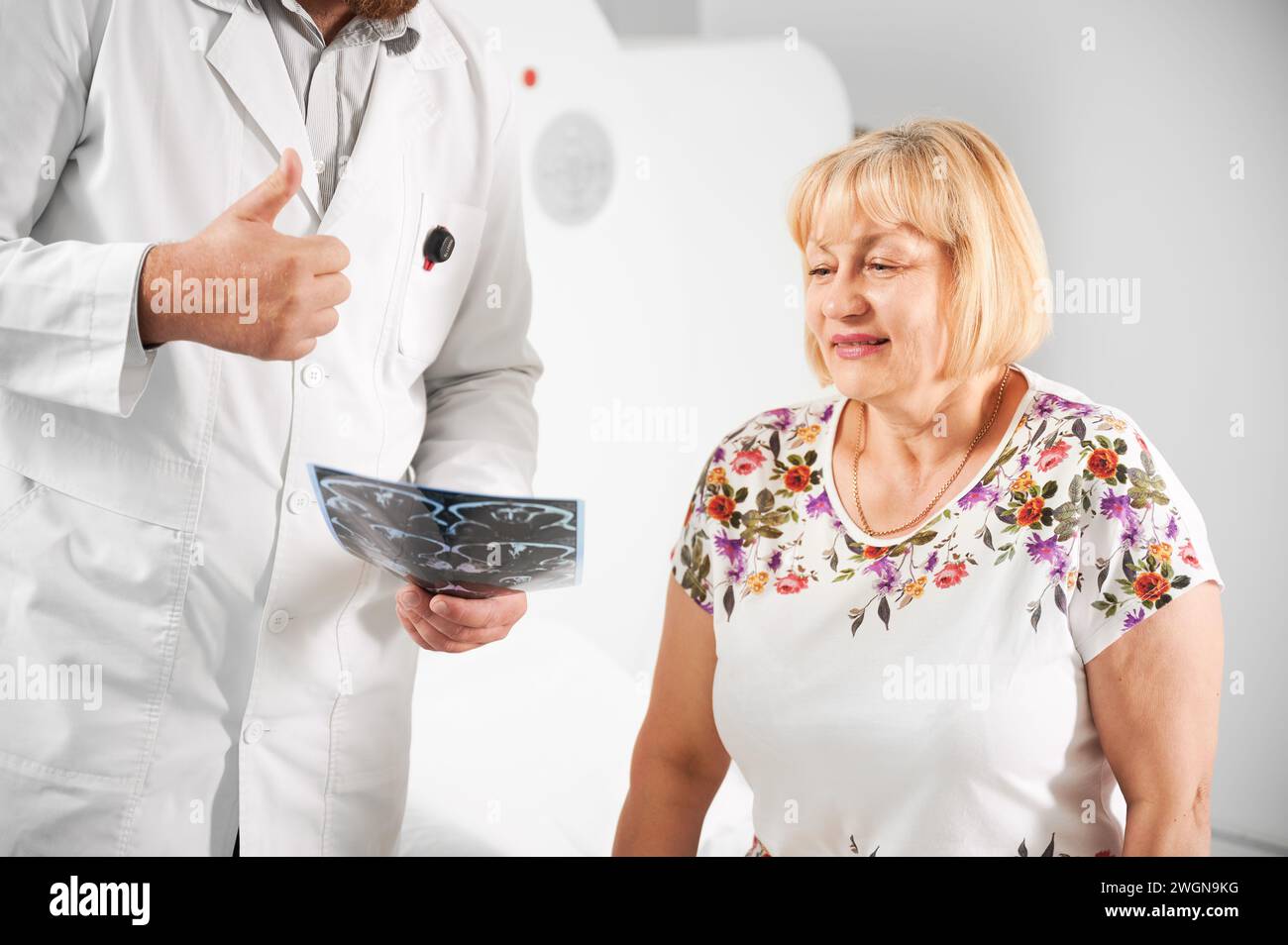 Patient making MRI, doctor holding and explaining results, showing ...