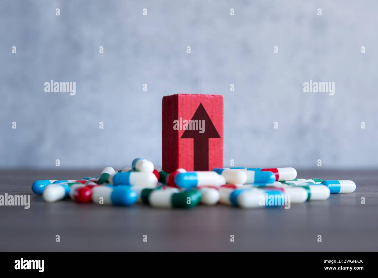 A red wooden block with upward-pointing arrow on a pile of colorful ...