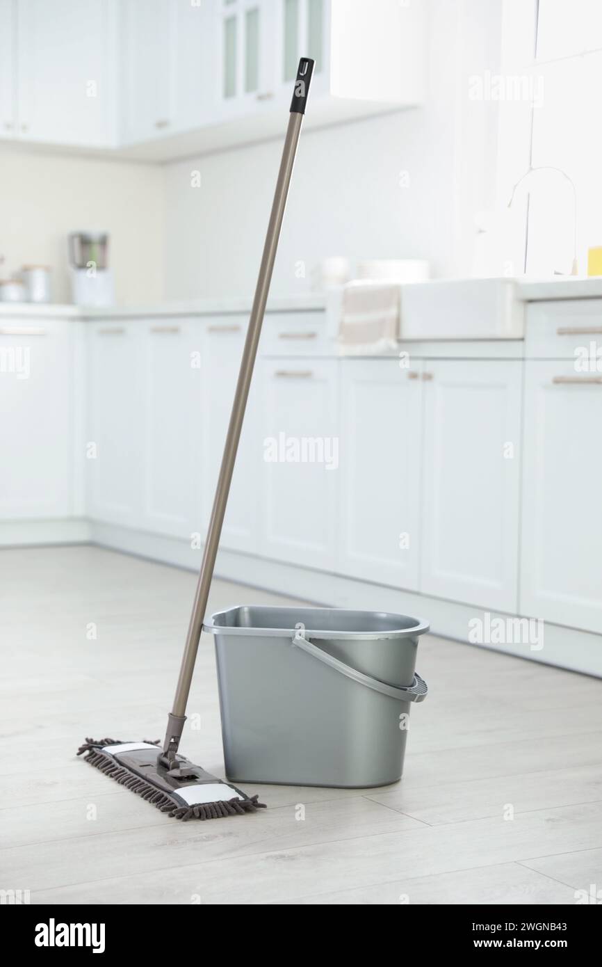 Mop and plastic bucket in kitchen. Cleaning supplies Stock Photo - Alamy