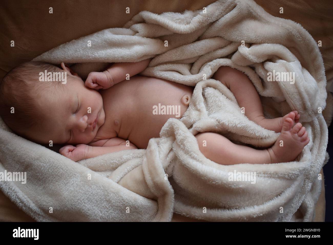 Sound asleep in a busy world, cozy and safe little baby boy Stock Photo ...