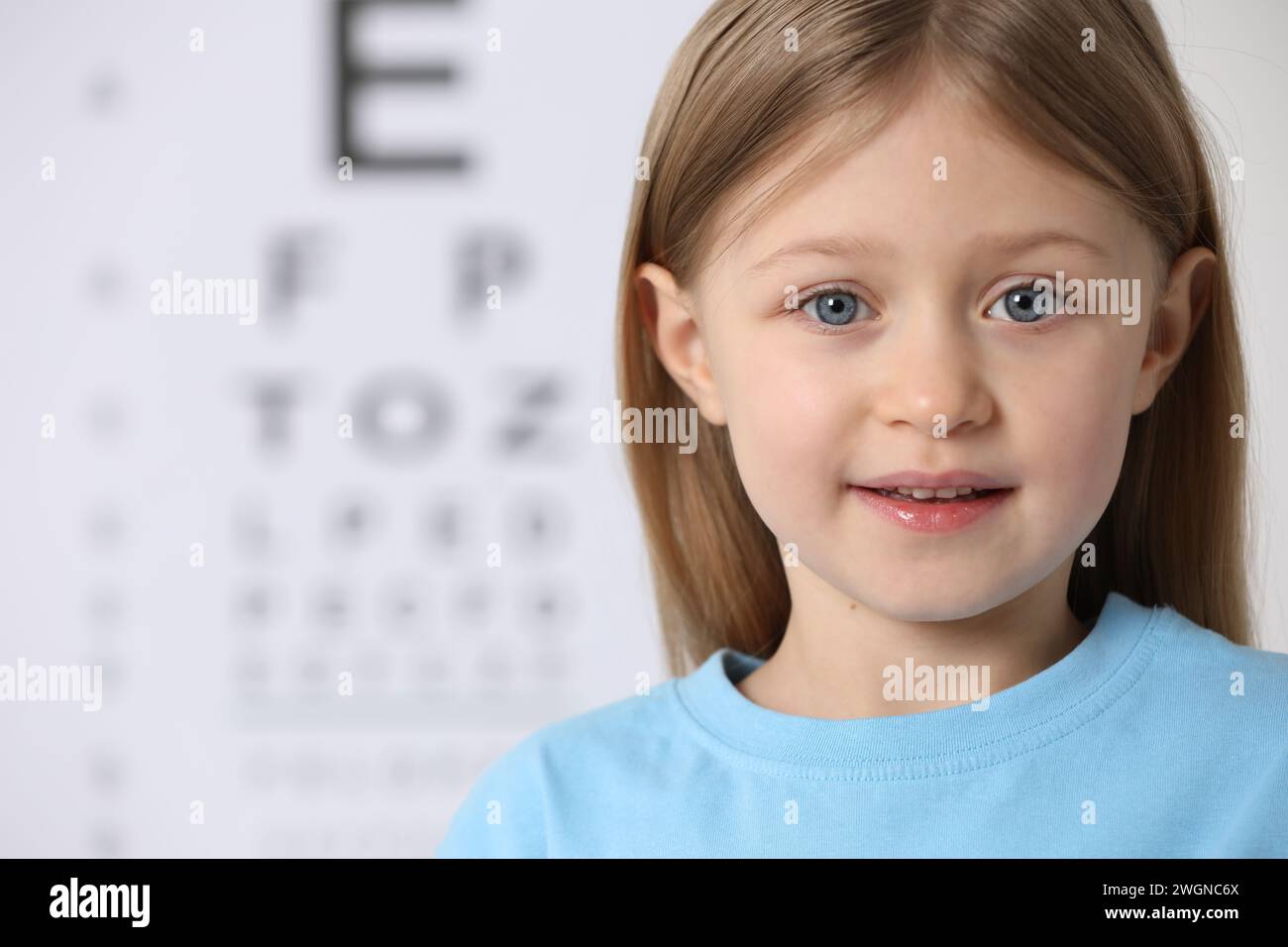 Cute little girl against vision test chart Stock Photo - Alamy