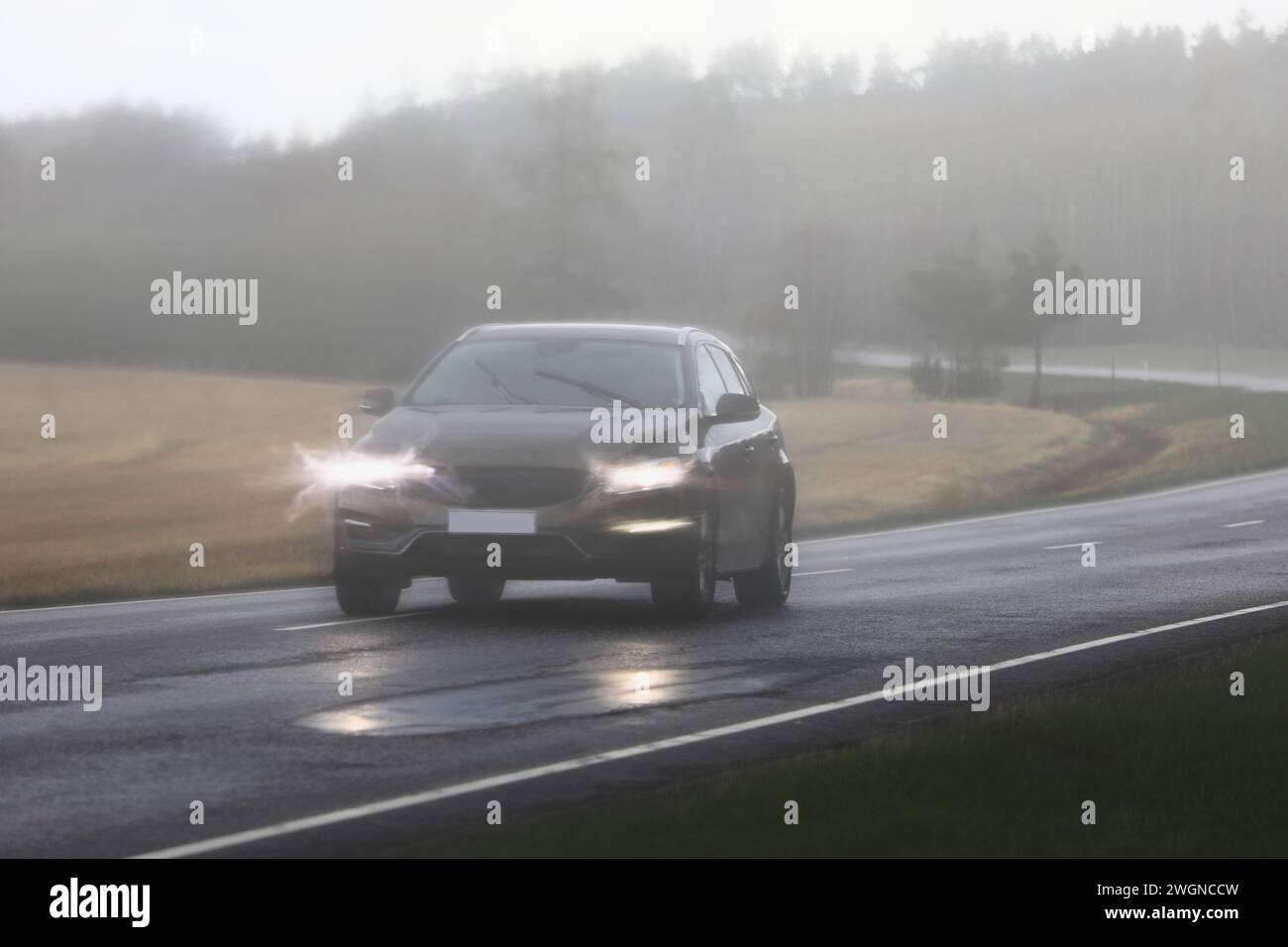 Car driving along highway on a rainy, stormy day with low visibility ...