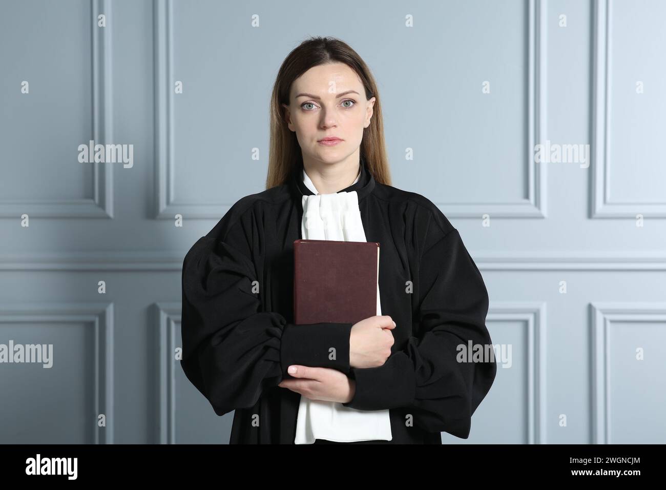 Portrait of judge with book near grey wall Stock Photo - Alamy