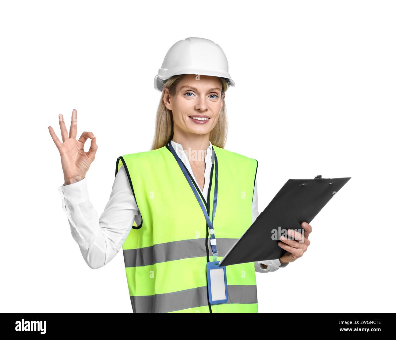Engineer in hard hat holding clipboard and showing ok gesture on white ...