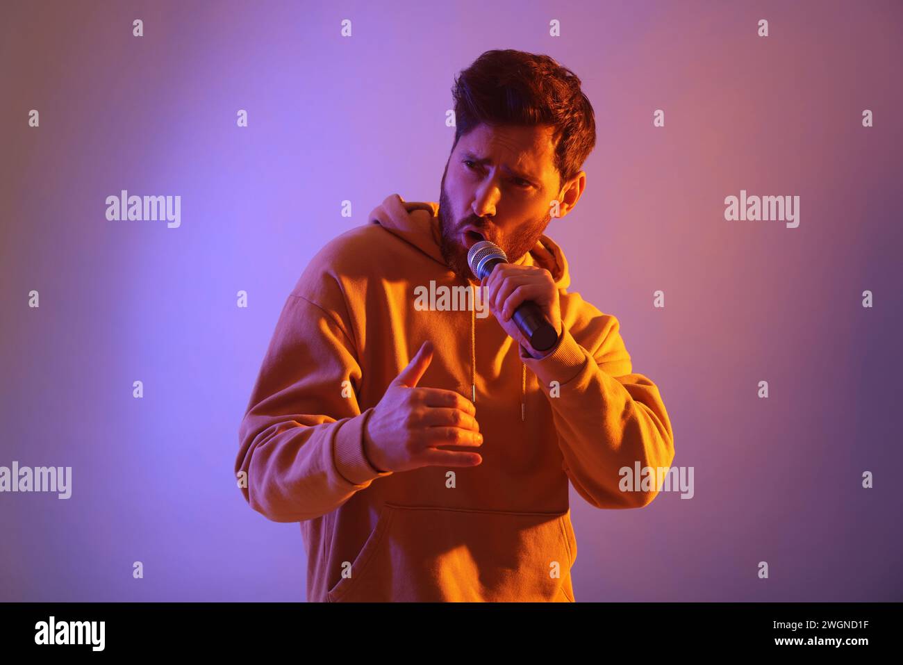 Singer with microphone rapping in color lights Stock Photo - Alamy