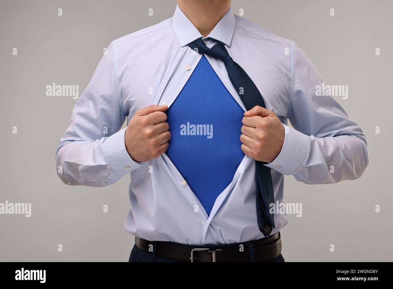 Businessman wearing superhero costume under suit on beige background, closeup Stock Photo - Alamy